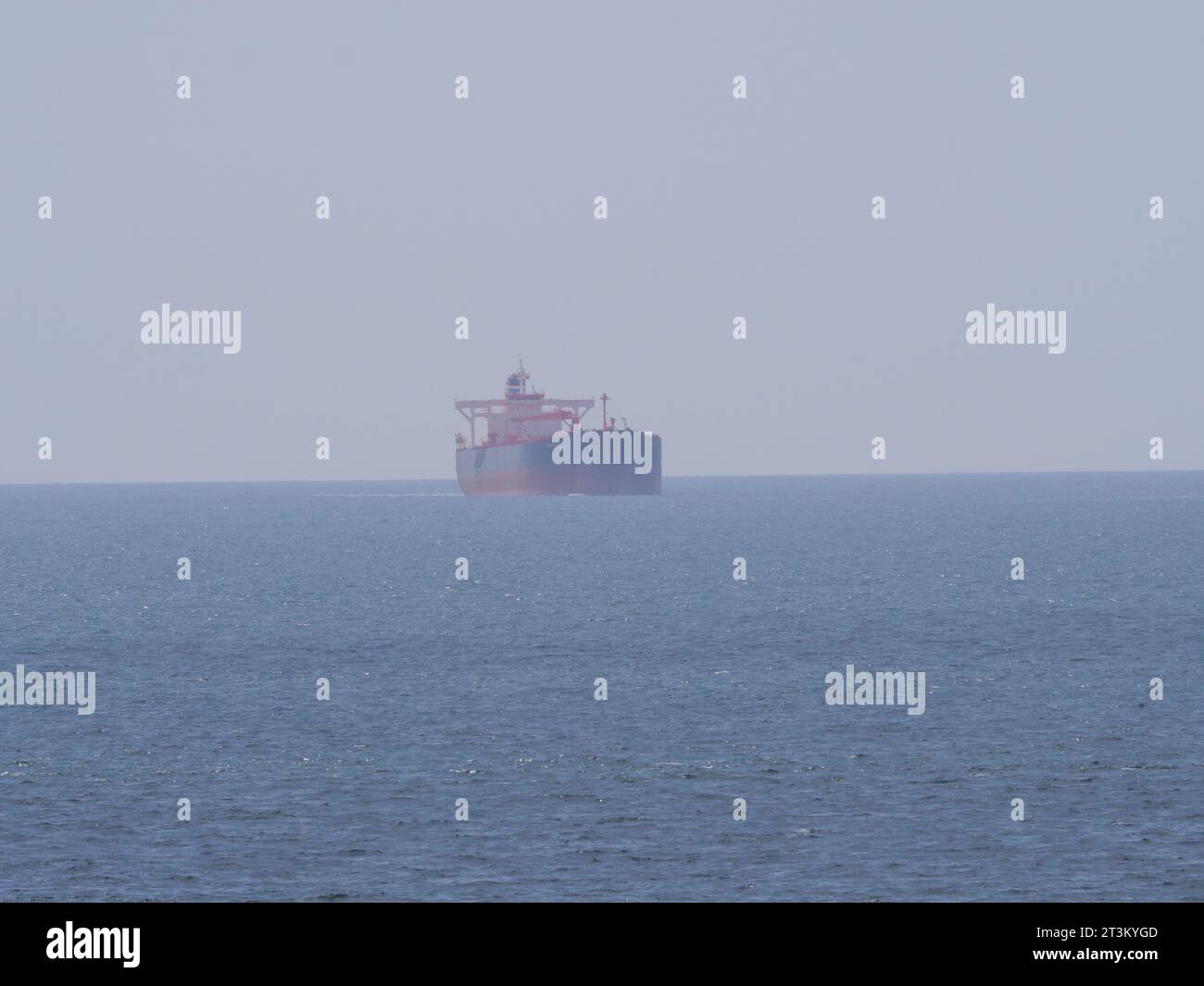 A large cargo ship sailing in the haze off the English coast near ...