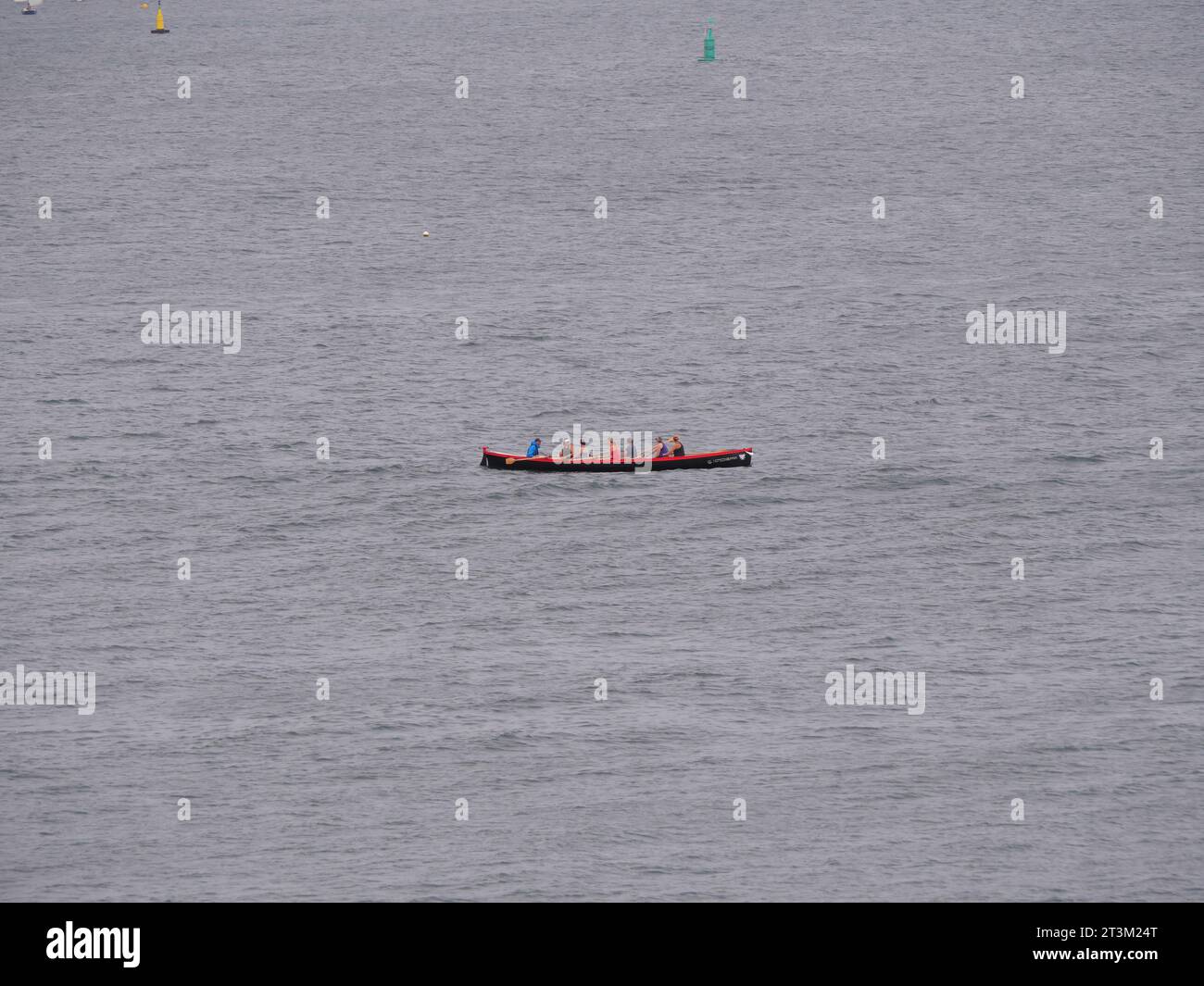 Seven people sitting in red rowing boat rowing across the sea Stock ...