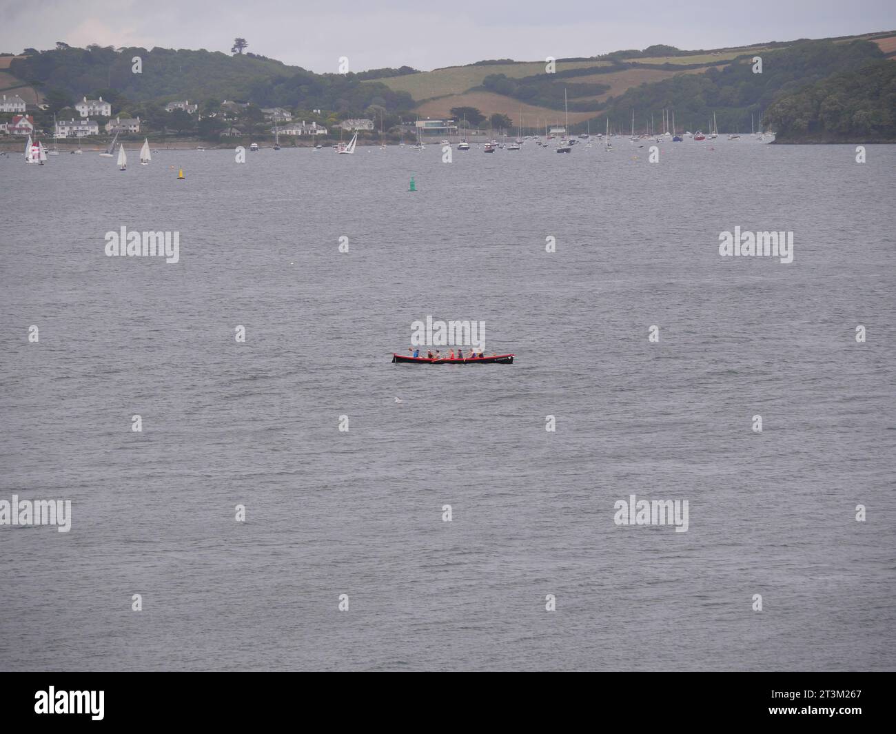 Seven people sitting in red rowing boat rowing across the sea Stock ...