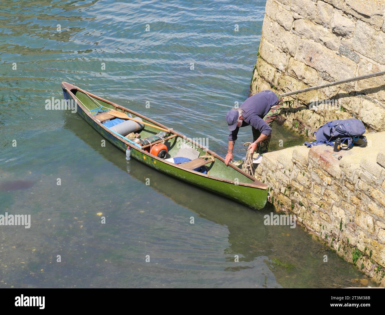A paddler loading his canoe in the harbour of Falmouth Cornwall England ...