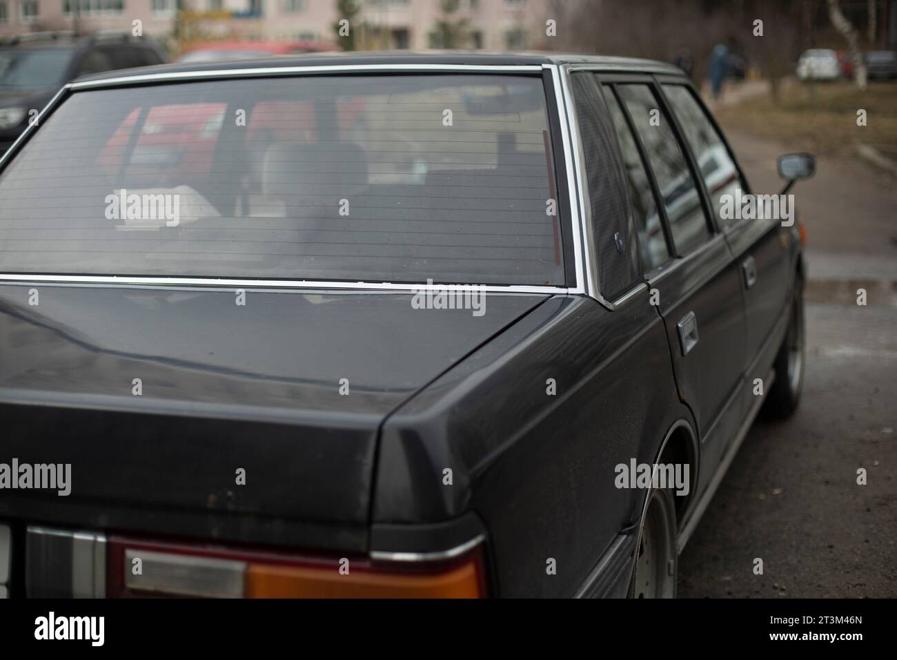 Old car in parking lot. Car is black. Car is removed from behind. Retro ...