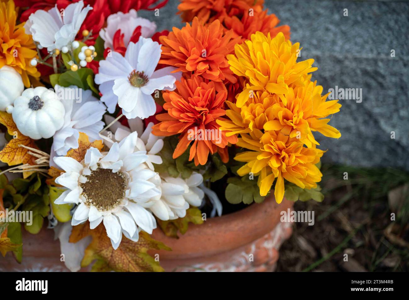 Basket of country fall colored silk flower arrangement by a graveside ...