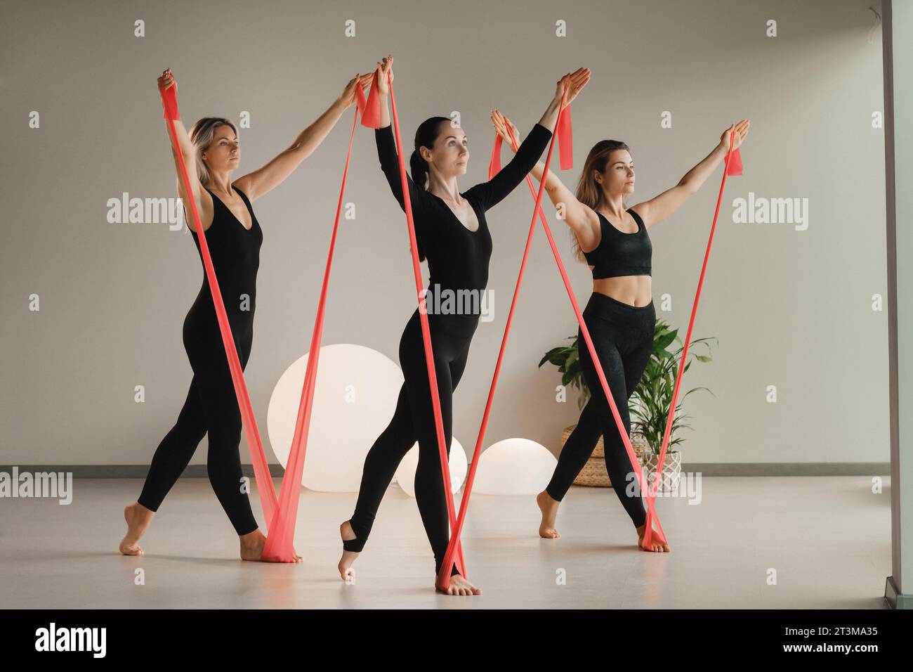 Girls in black are doing fitness with red ribbons indoors Stock Photo ...