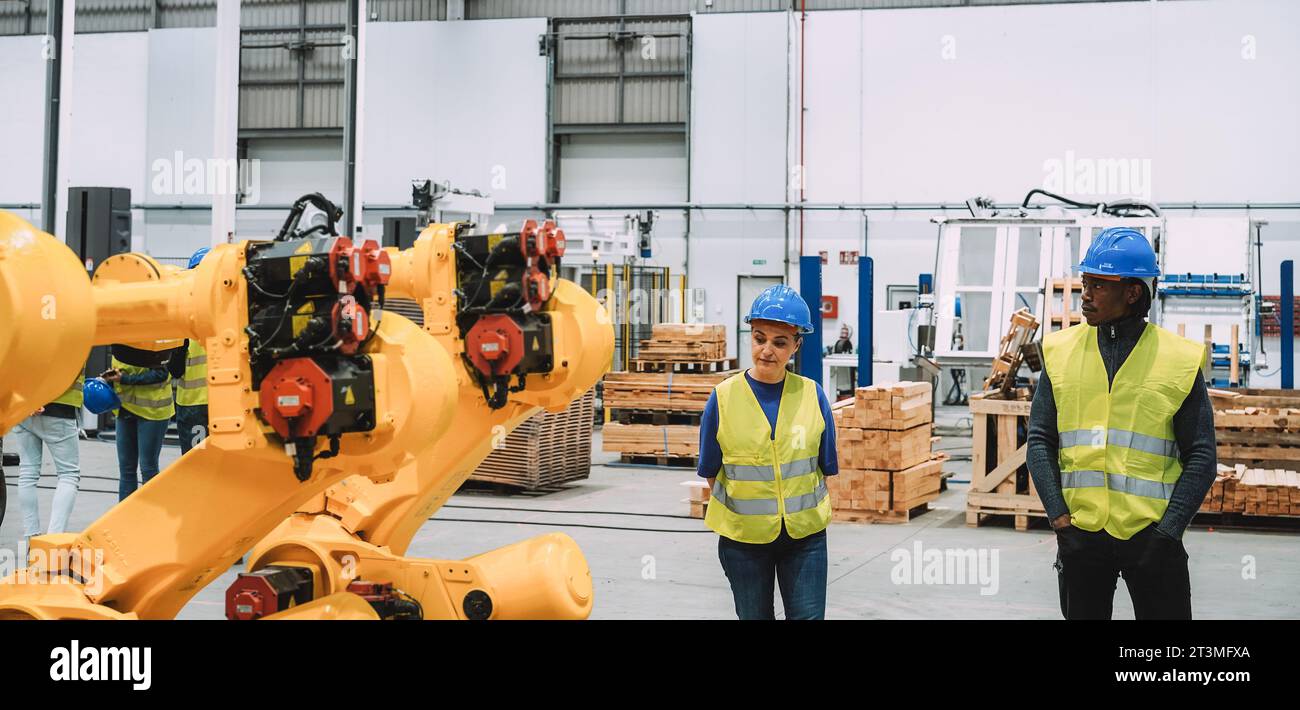 Multiracial workers inside robotic factory - Artificial intelligence ...