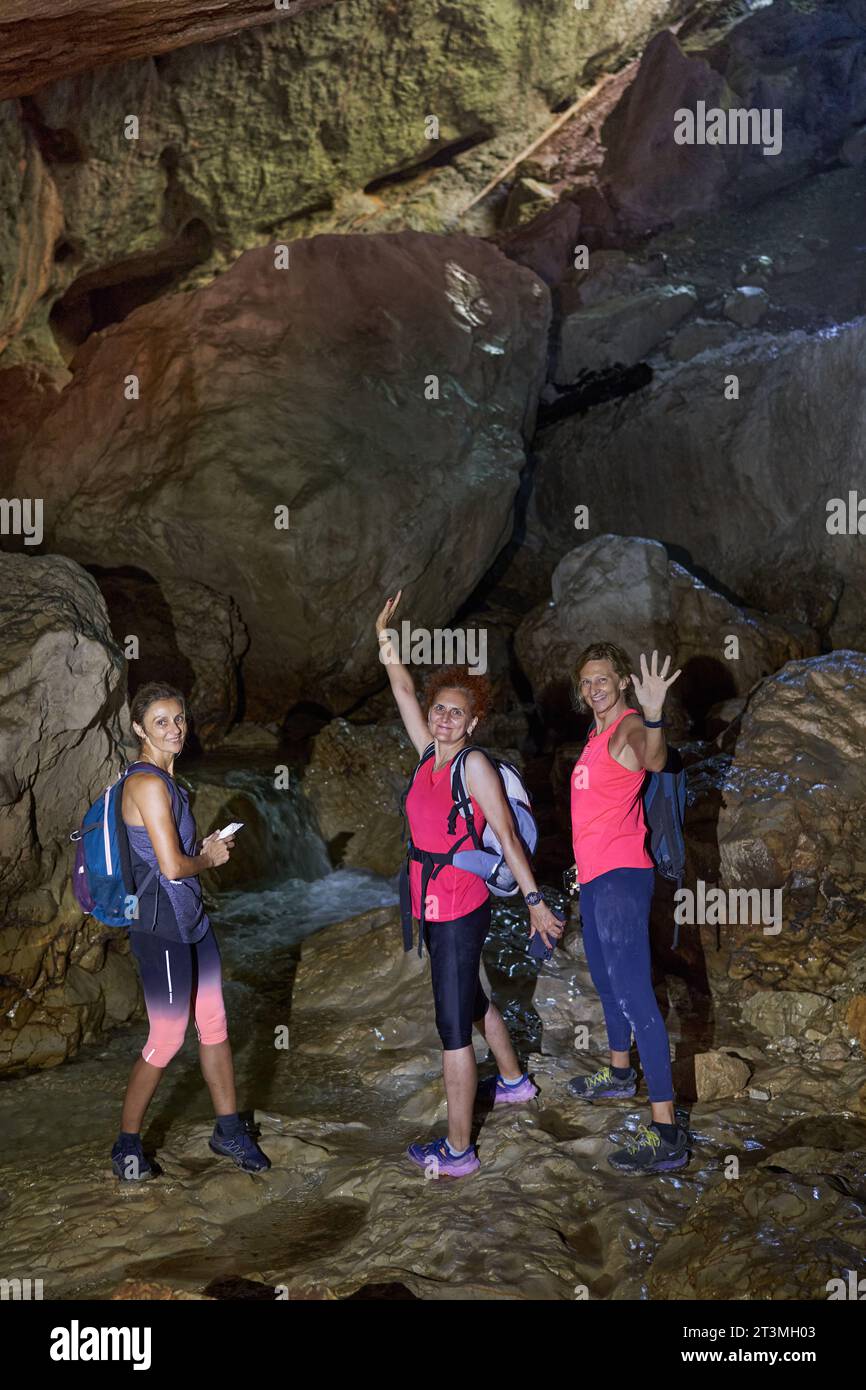 Three women with backpack exploring a cave with head torches Stock ...