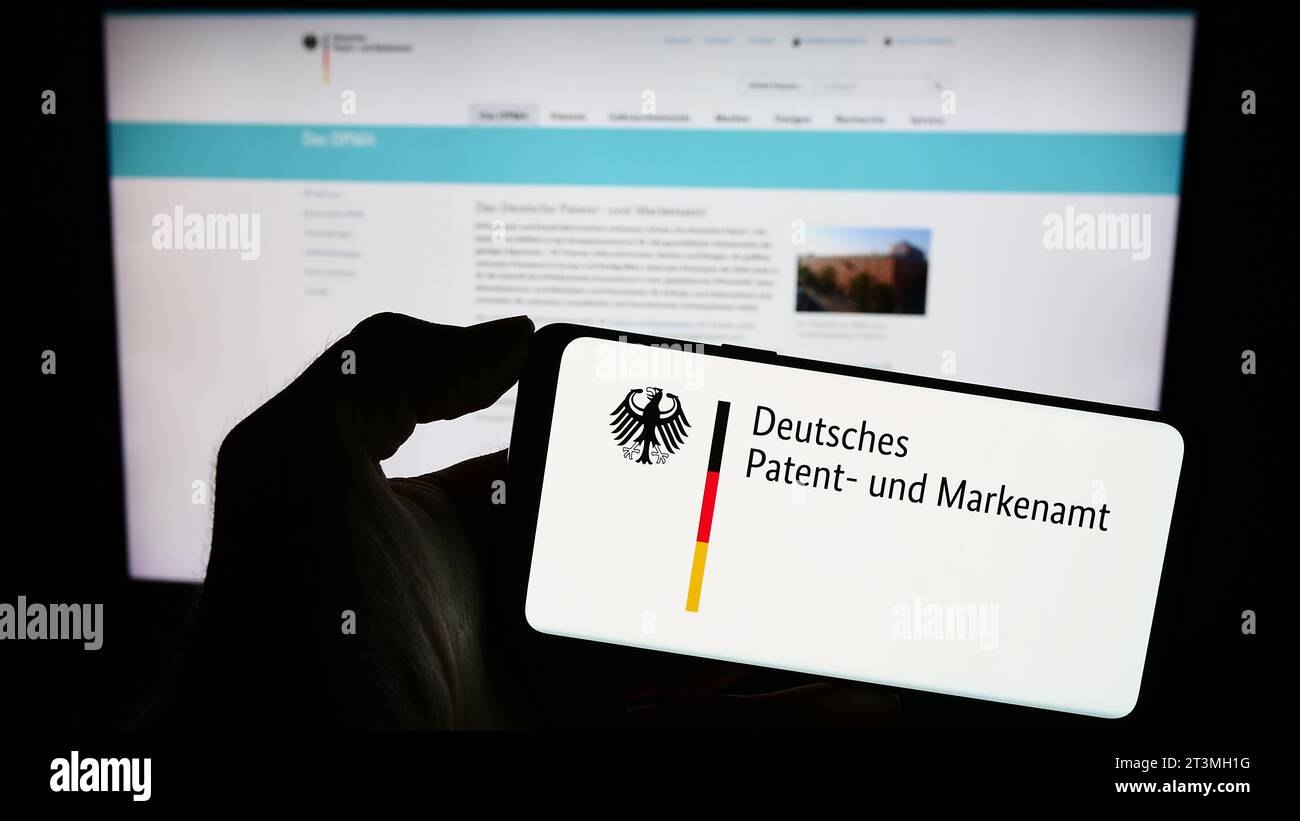 Person holding mobile phone with logo of German agency Deutsches Patent ...