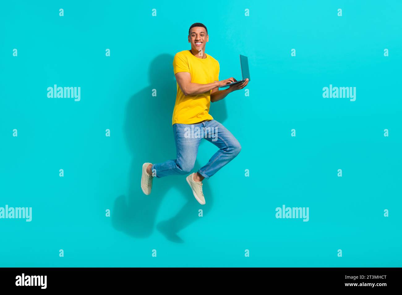 Full Size Photo Of Cheerful Energetic Person Jumping Hold Use Wireless Netbook Isolated On Teal