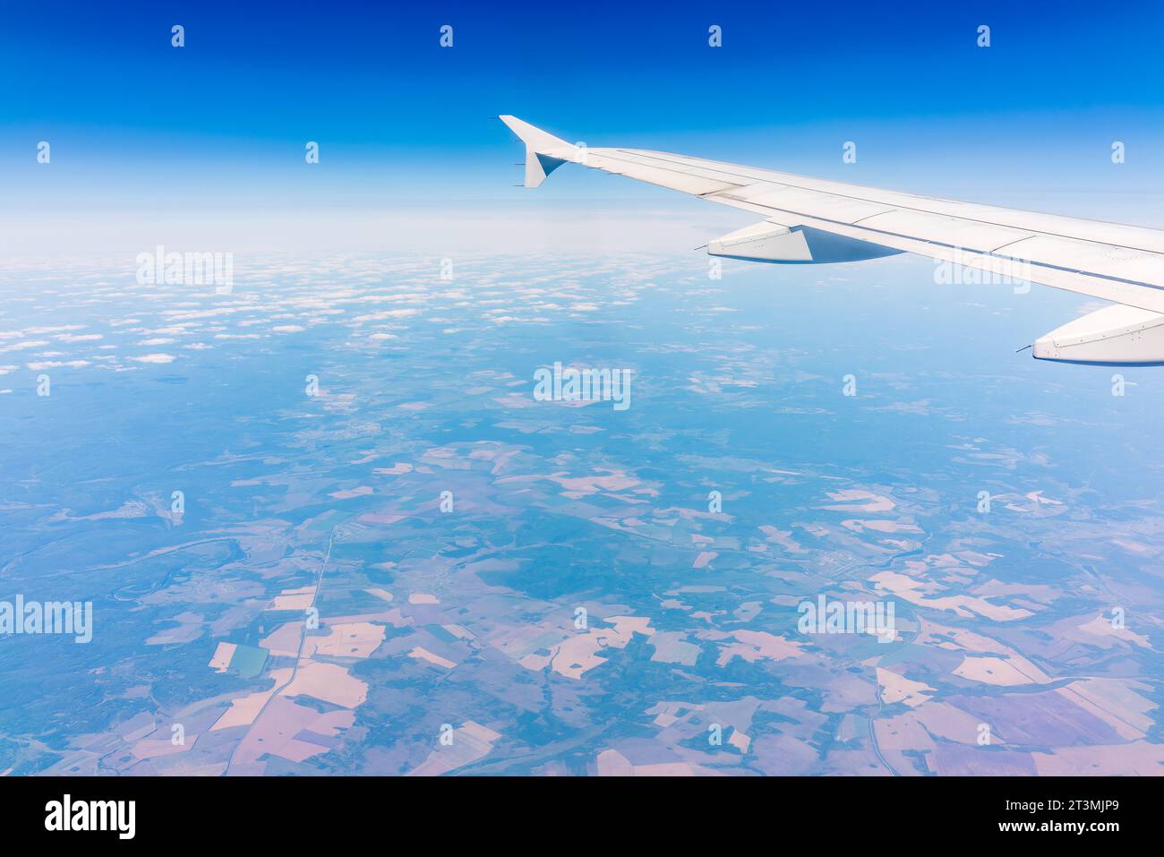 Aerial view from airplane window above green ground. View from the ...