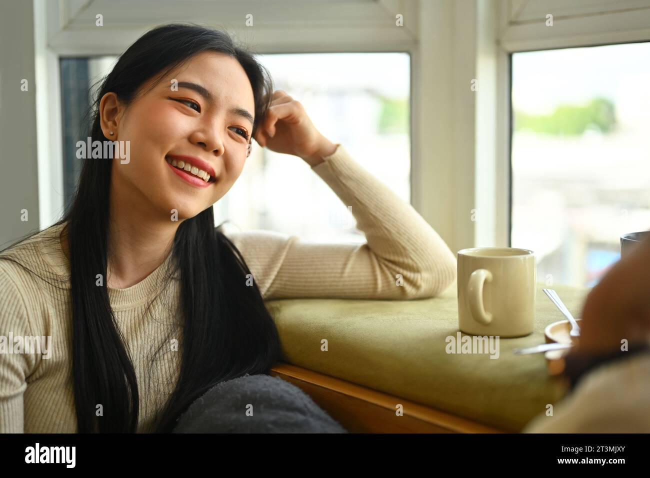 Happy smiling asian woman having pleasant conversation with friend and ...