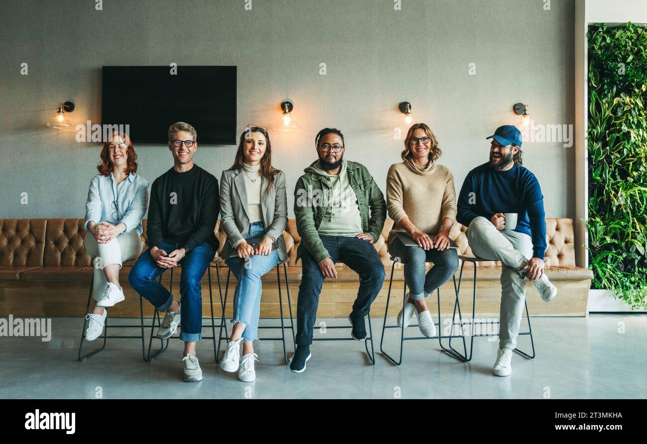 Portrait of a happy group of business colleagues seated together in a ...