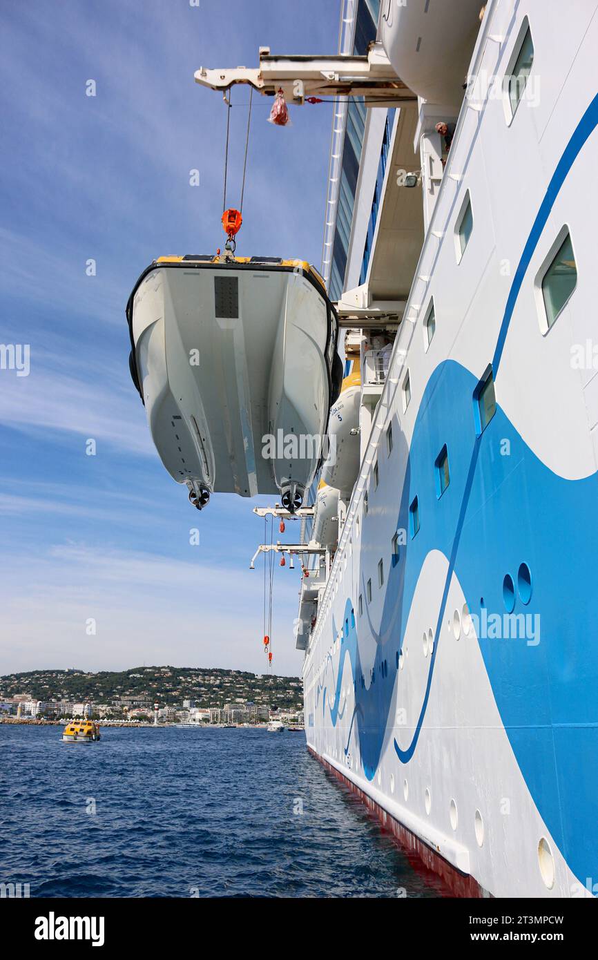 Davits raising a tender lifeboat from the sea to the promenade deck of ...