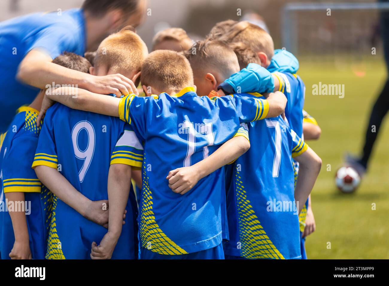 The soccer team huddles in a circle with a coach during the time break ...