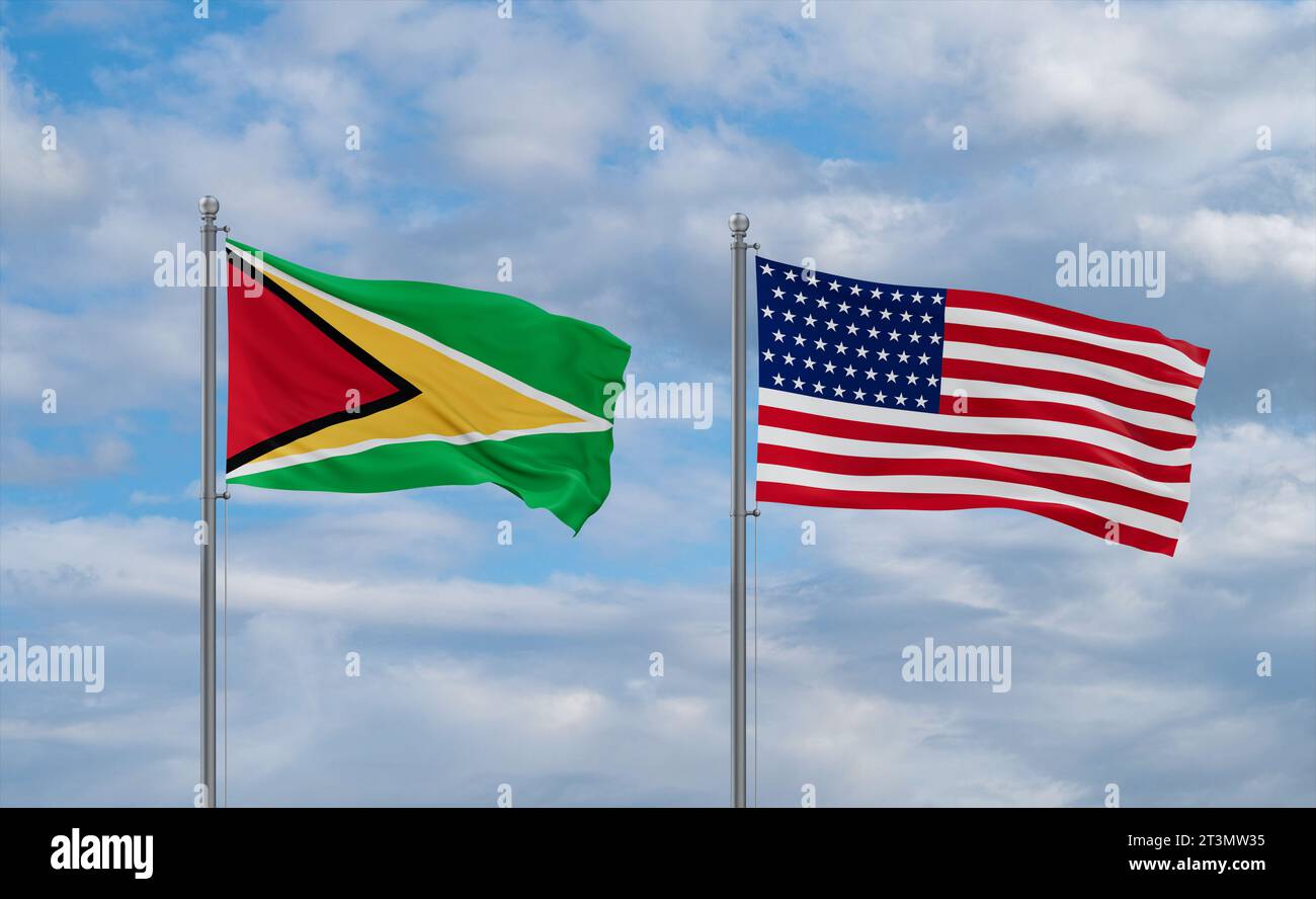 USA and Guyana flags waving together in the wind on blue cloudy sky ...