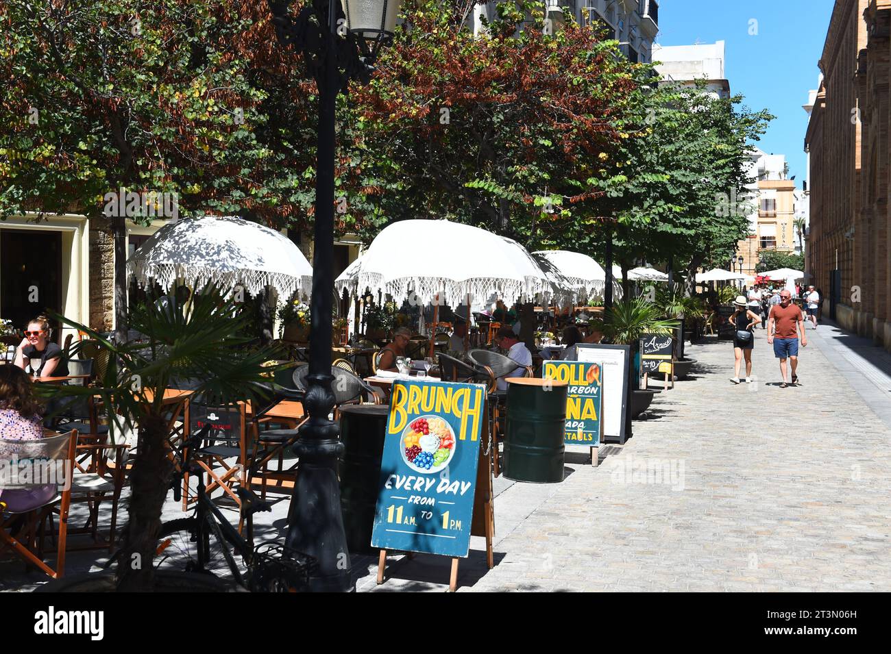 Pedestrians walk along designated walkway, locals and tourists sit at ...