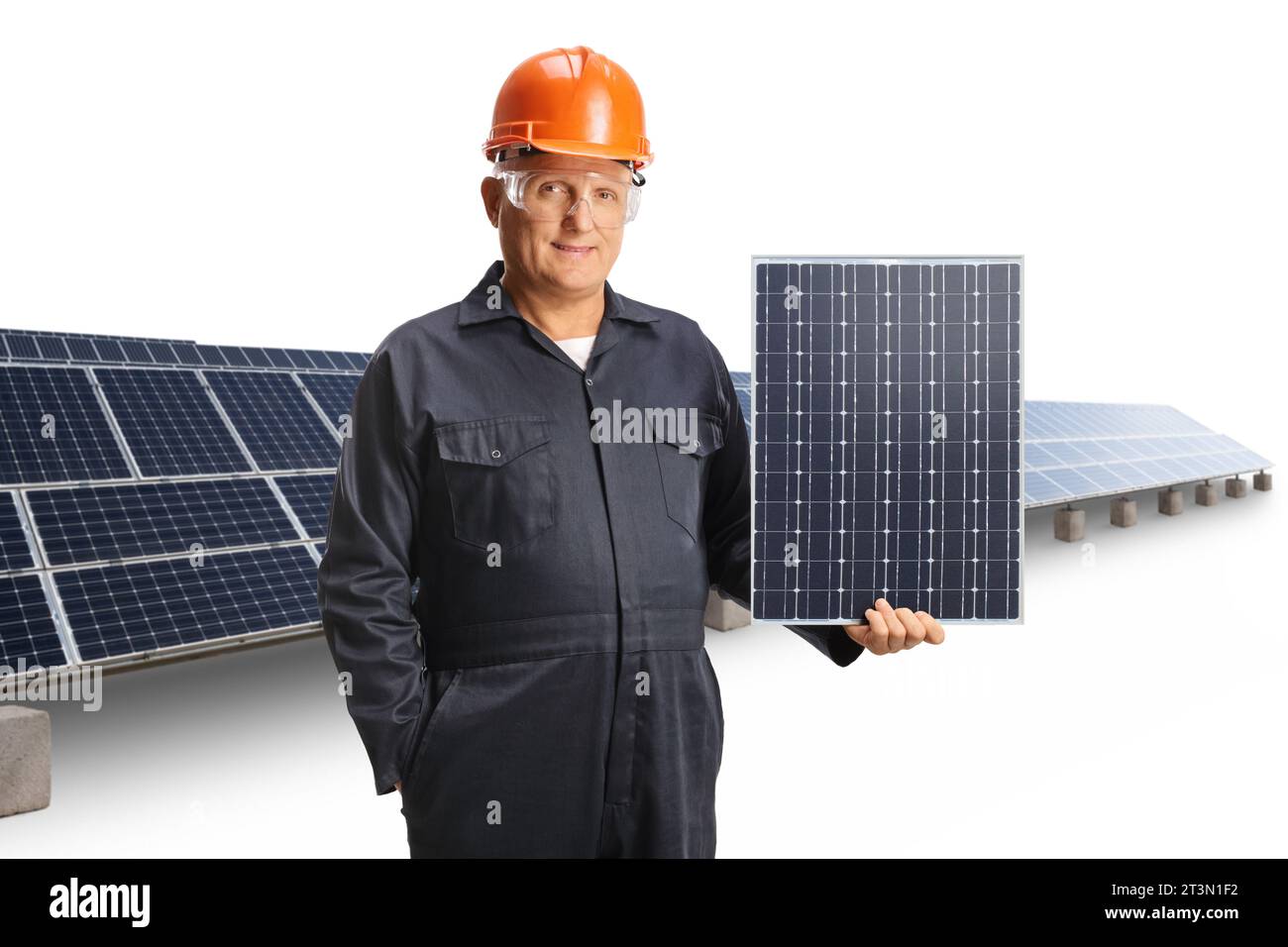 Male worker in a uniform holding a solar panel in front of photovoltaic ...