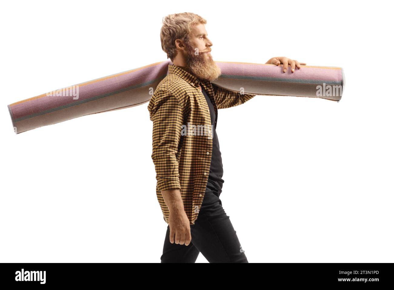 Profile shot of a guy walking and carrying a carpet on his shoulder ...