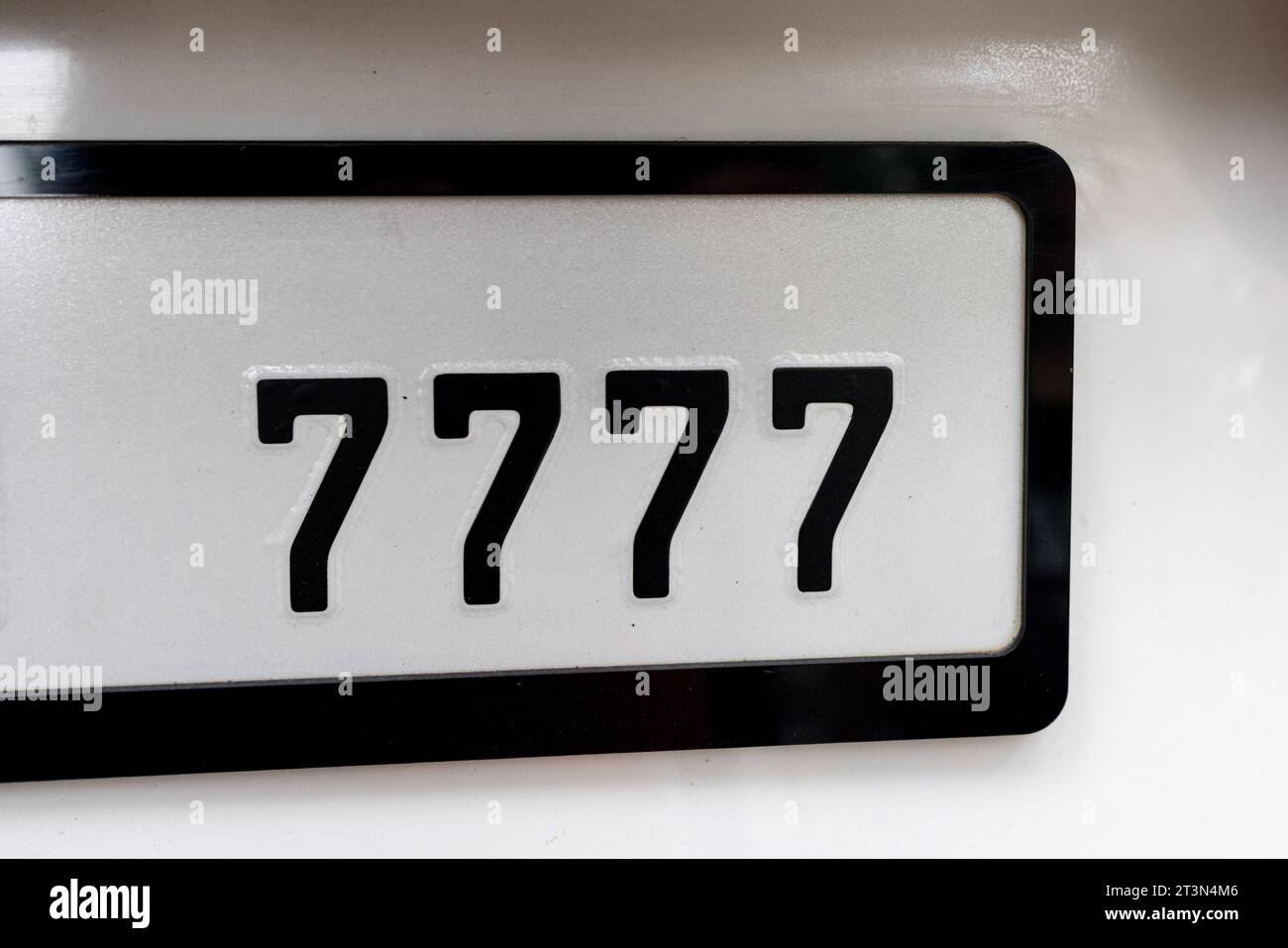 A piece of a decorative license plate with four sevens. License plates ...