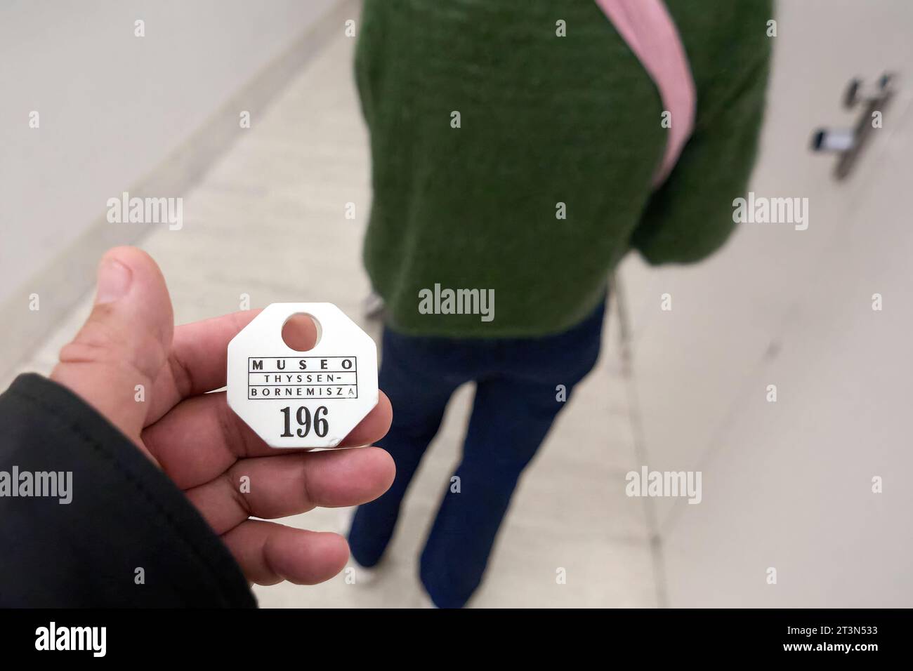 MADRID SPAIN - October 26, 2023: Hand holding cloakroom token of the ...