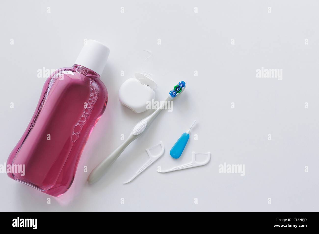 Top view of dental floss, toothbrush, toothpicks and rinse on white ...