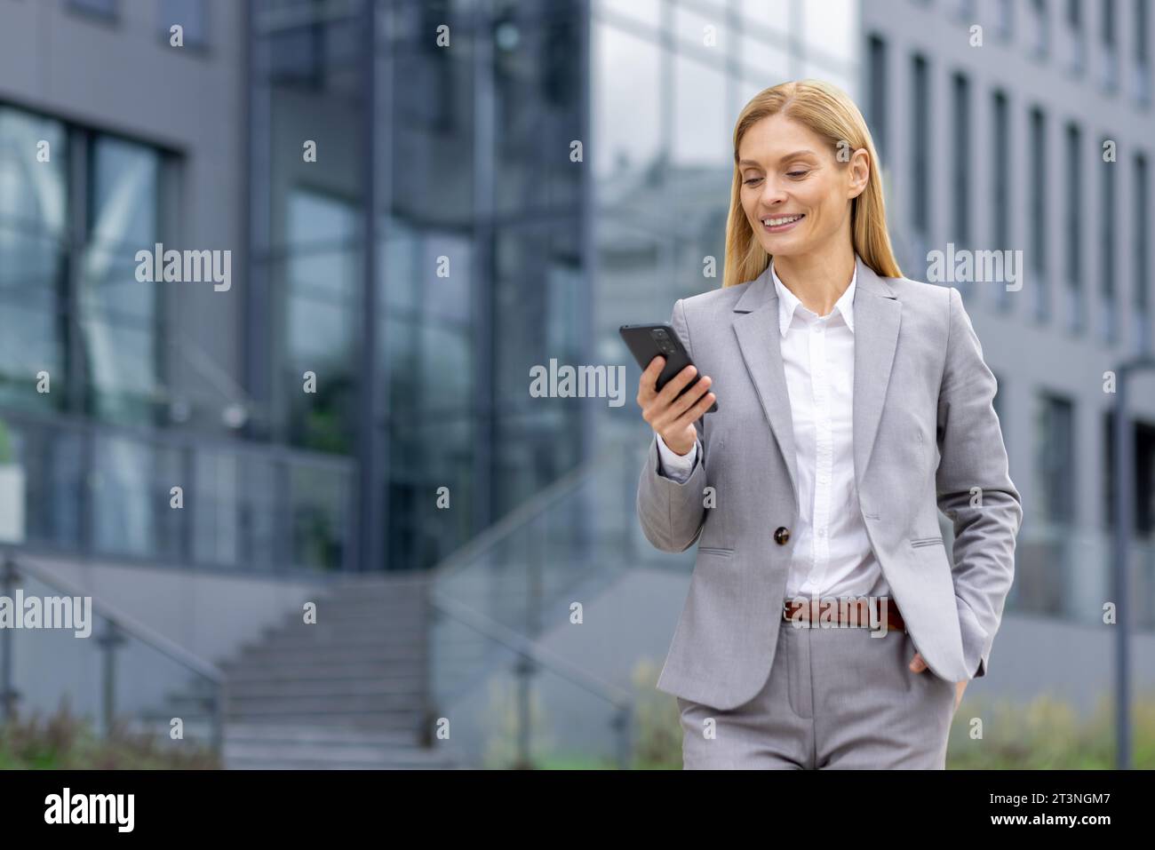 Successful woman boss walks outside office building outdoors, in ...