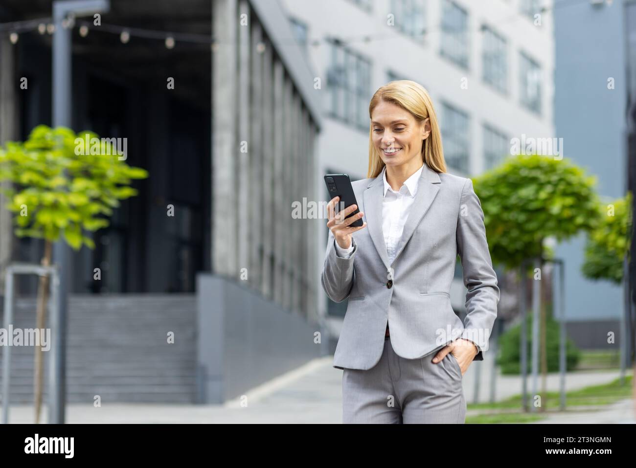 Successful woman boss walks outside office building outdoors, in ...