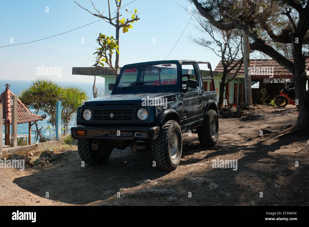 Behold the allure of the seaside as a dark blue jeep stands proudly by ...