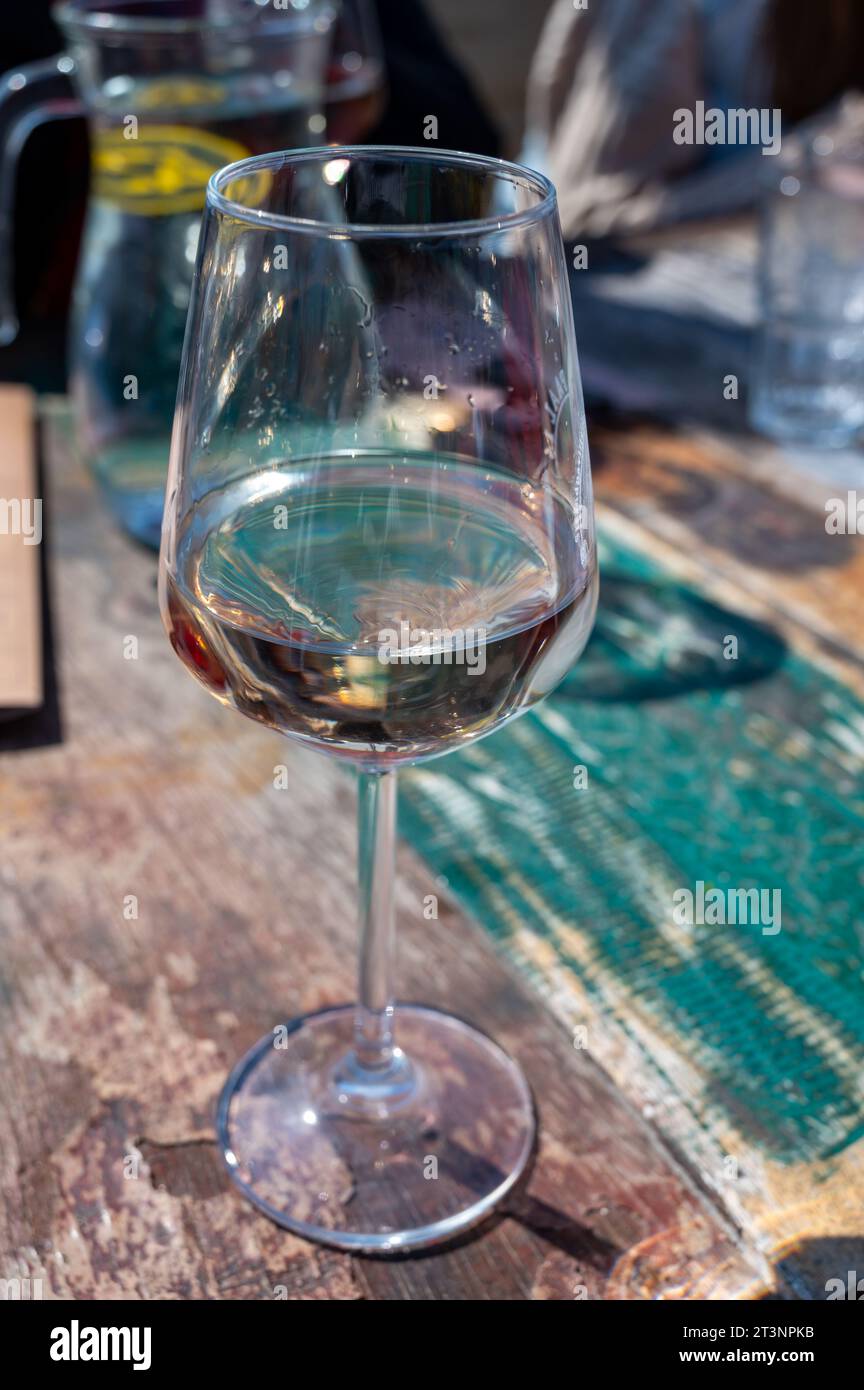 Drinking of pinot grigio dry cold wine, served outdoor in beach cafe in ...