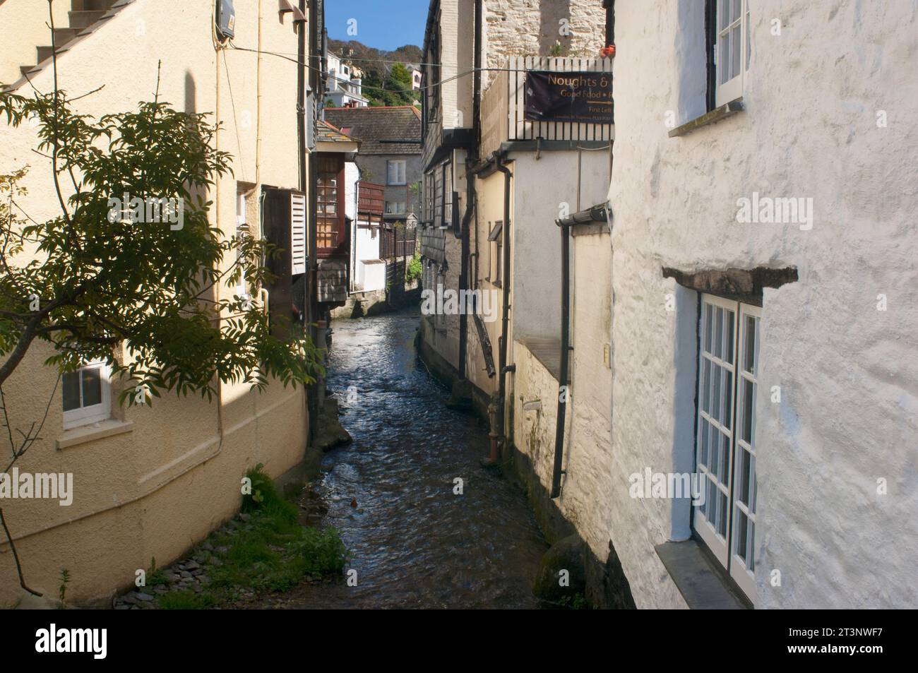 A stream flowing between houses before entering the harbour at Polperro ...
