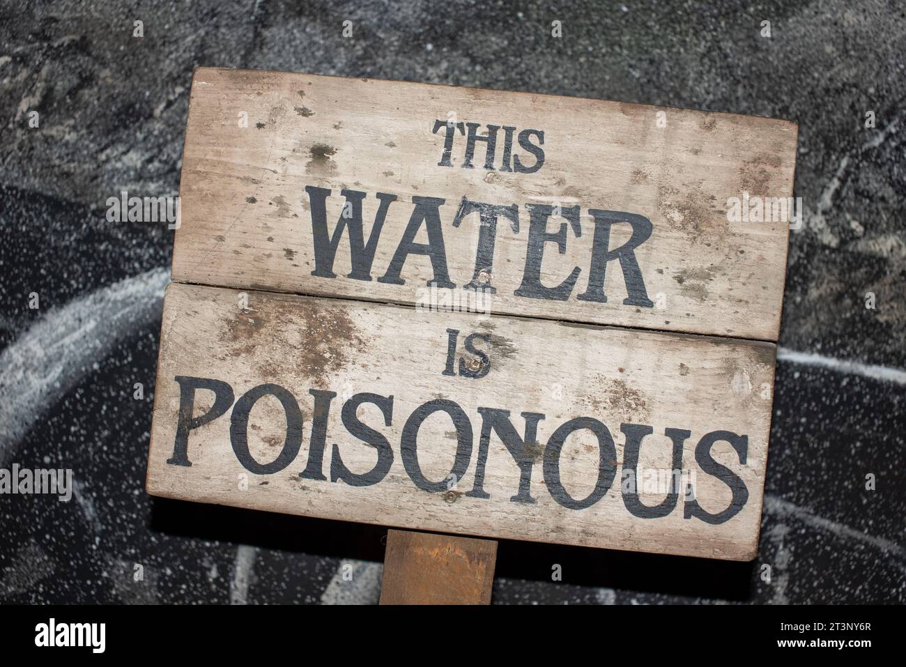 Wooden sign with writing stating this water is poisonous Stock Photo ...