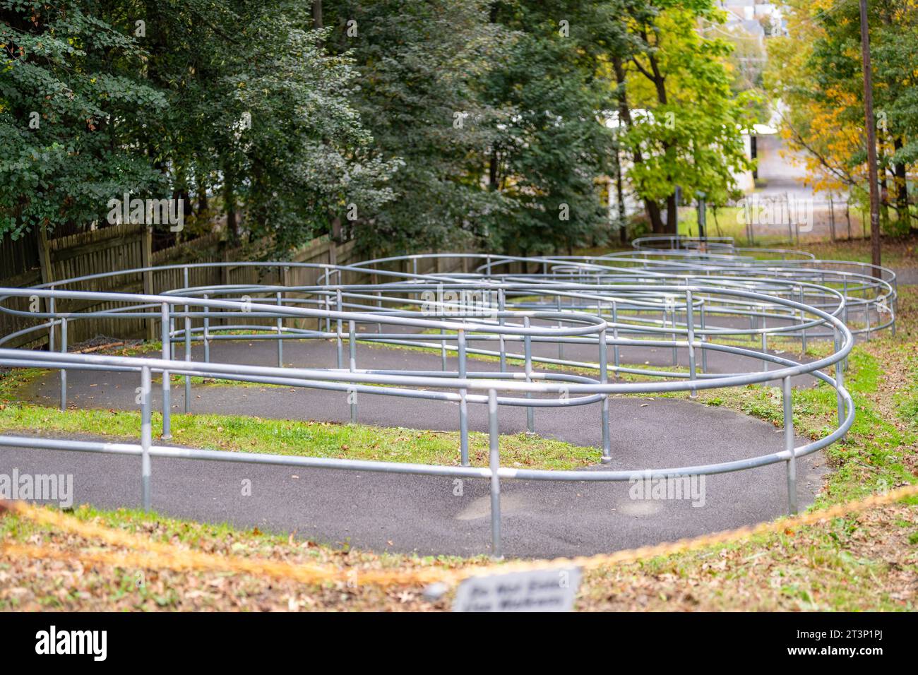 Asphalt sidewalk with steel railings with multiple returns and bends ...