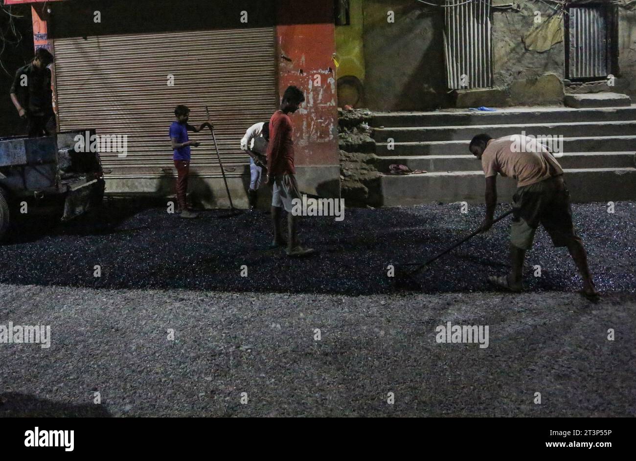 Kathmandu, Bagmati, Nepal. 26th Oct, 2023. Indian migrant workers spread hot asphalt while ...
