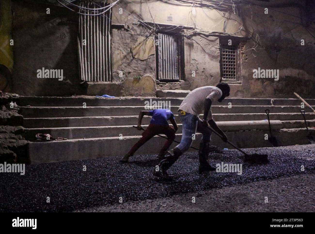 Kathmandu, Bagmati, Nepal. 26th Oct, 2023. Indian migrant workers spread hot asphalt while ...