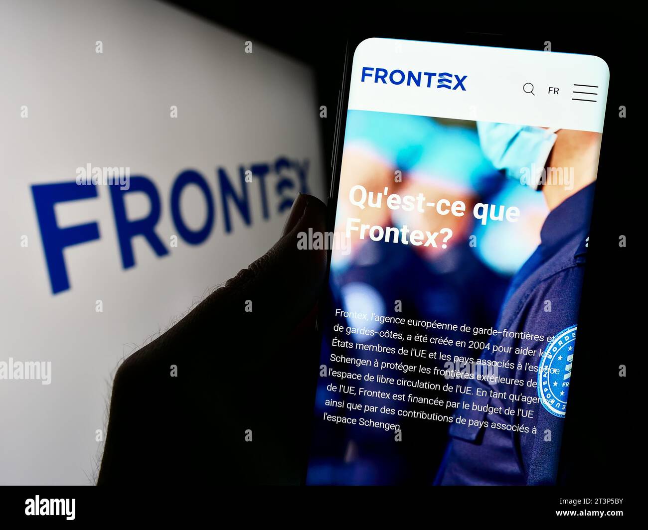 Person holding smartphone with webpage of European Border and Coast ...