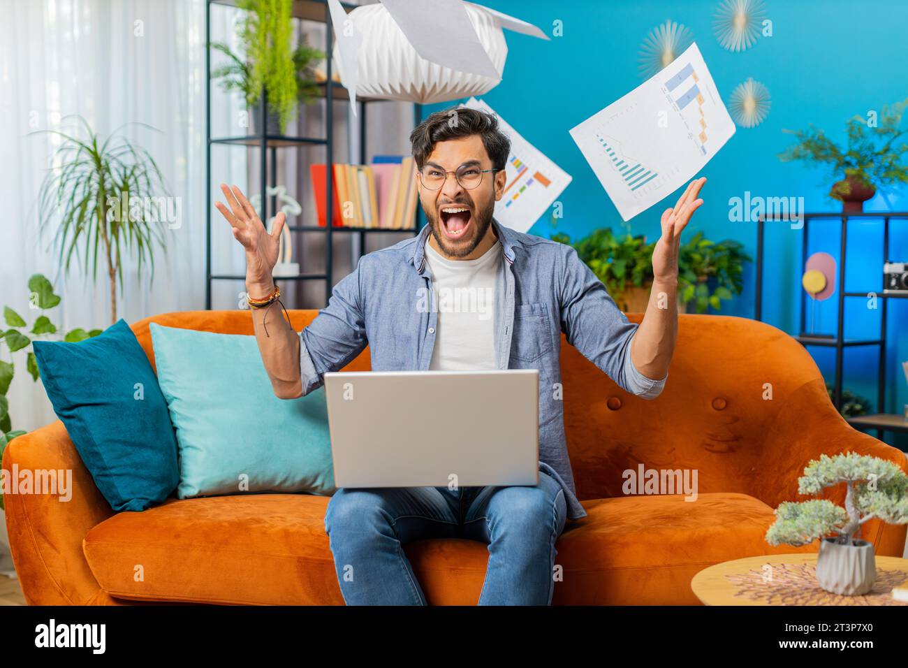 Displeased guy throws paper bills overhead. Stressed Indian man working ...