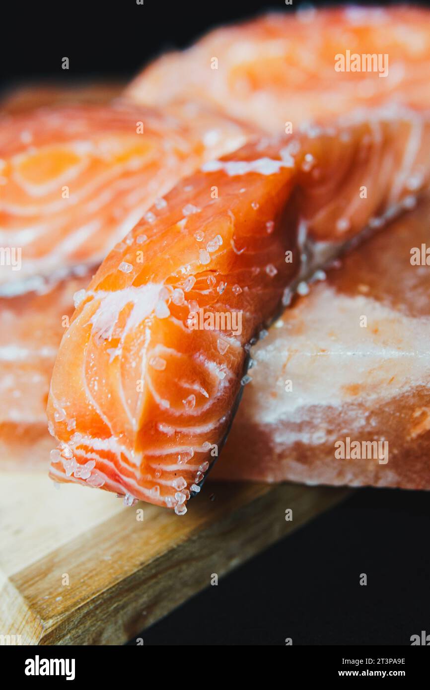 Fresh raw salmon fillet with seasonings and herbs on the block of ...