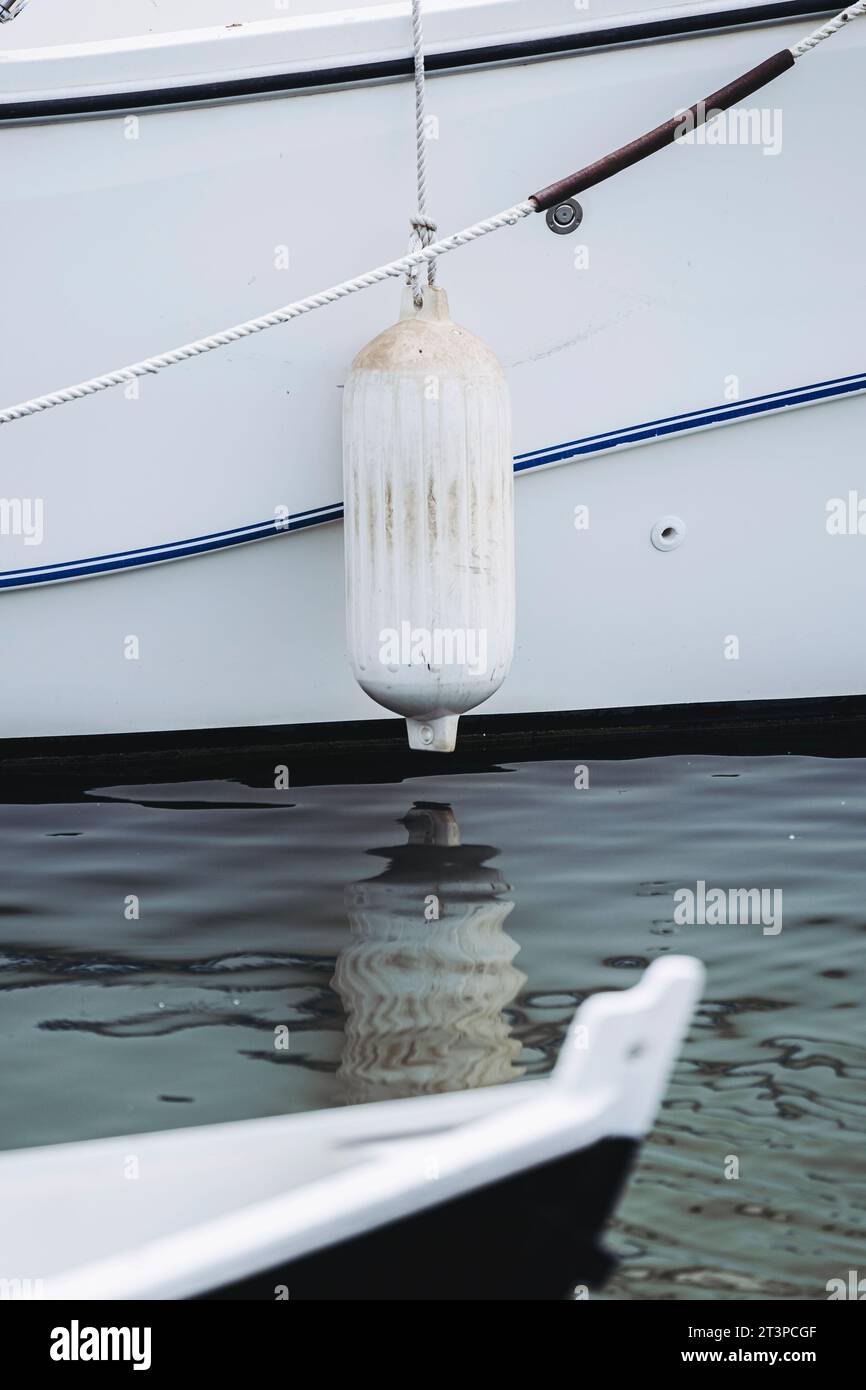 Flotation buoy hanging from a small boat in the harbor Stock Photo - Alamy