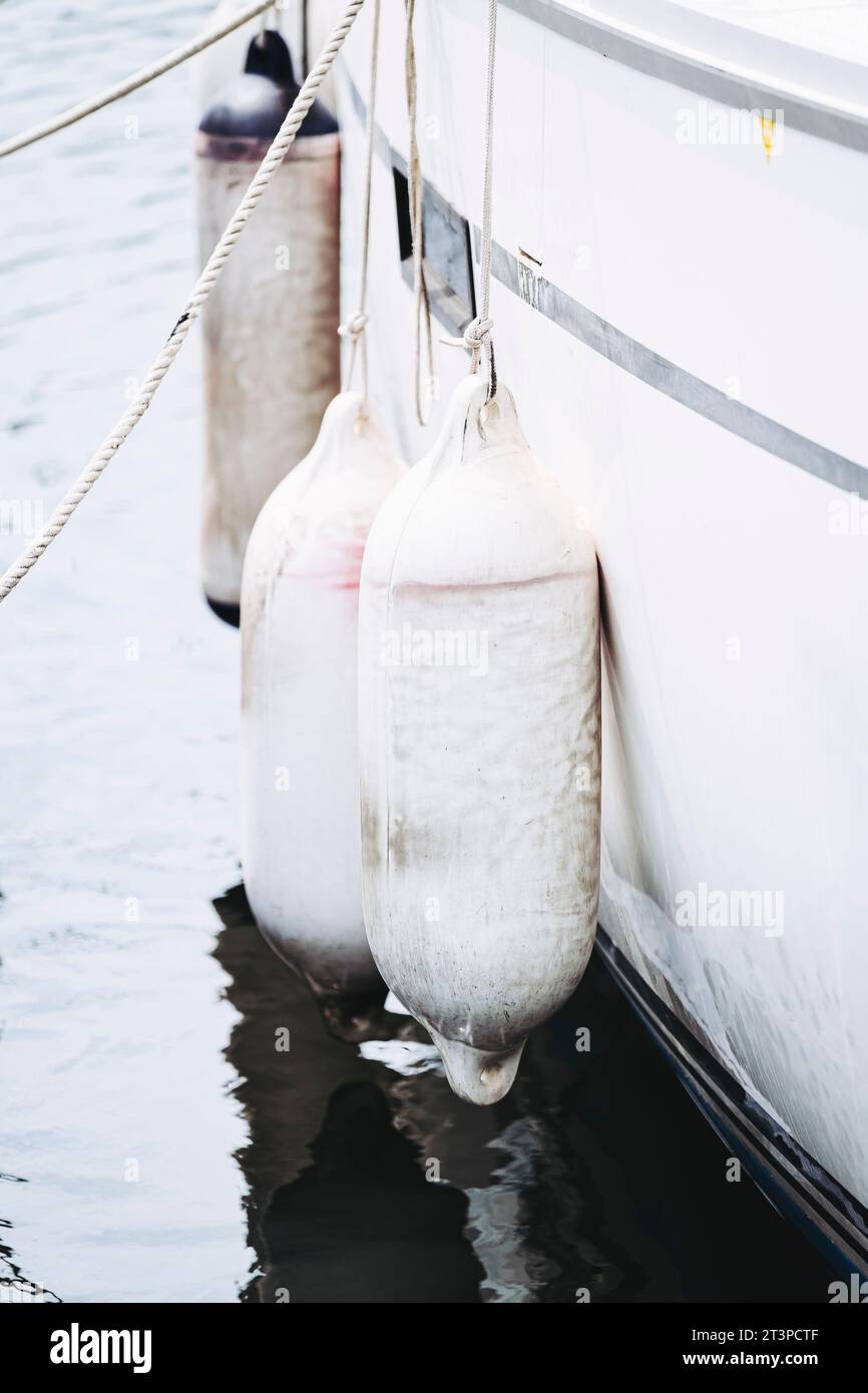 Flotation buoy hanging from a small boat in the harbor Stock Photo - Alamy