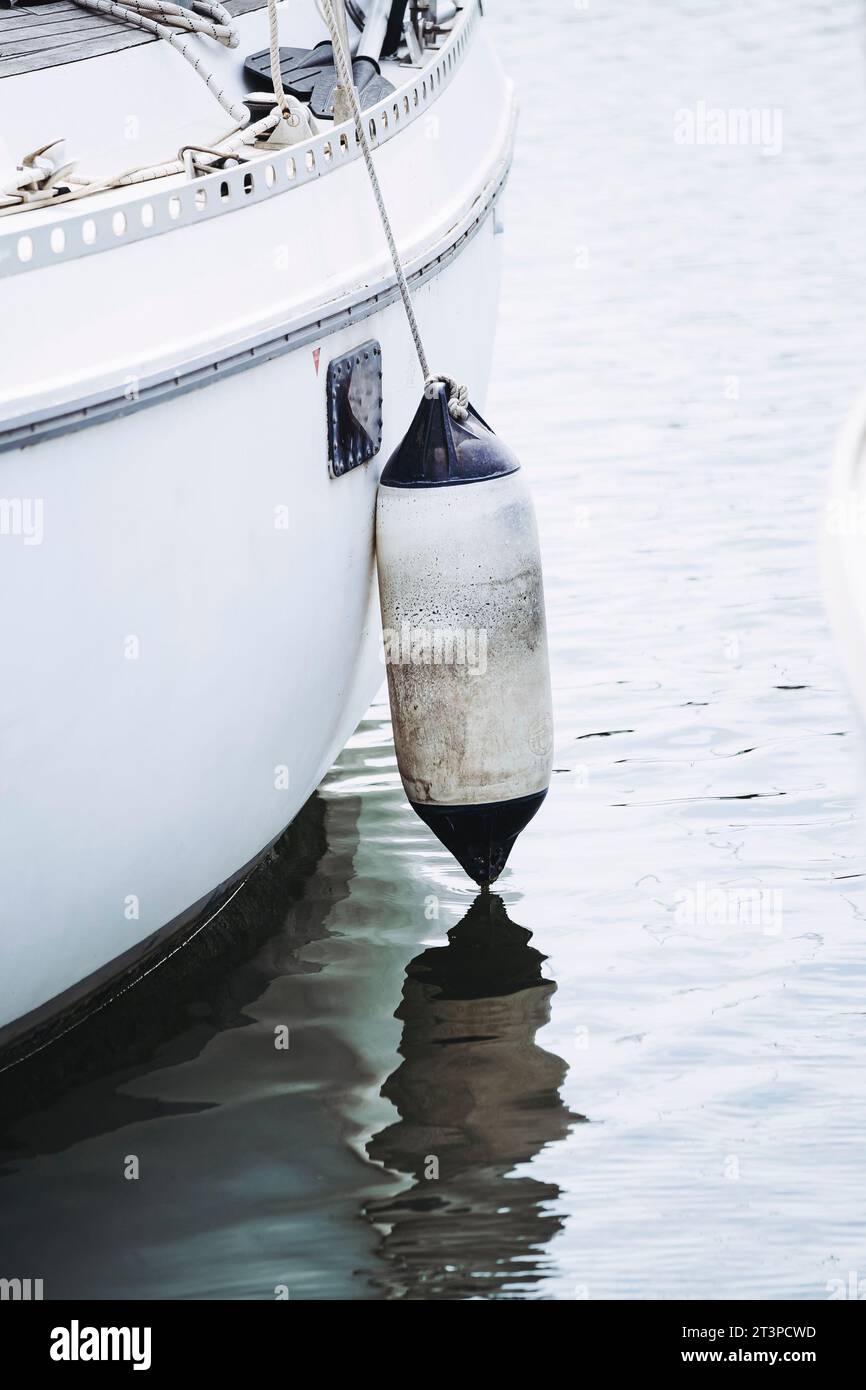 Flotation buoy hanging from a small boat in the harbor Stock Photo - Alamy
