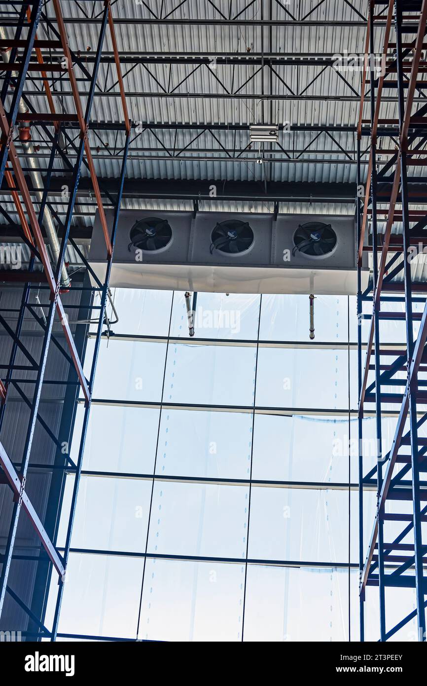 An industrial refrigeration evaporator in front of a translucent window ...
