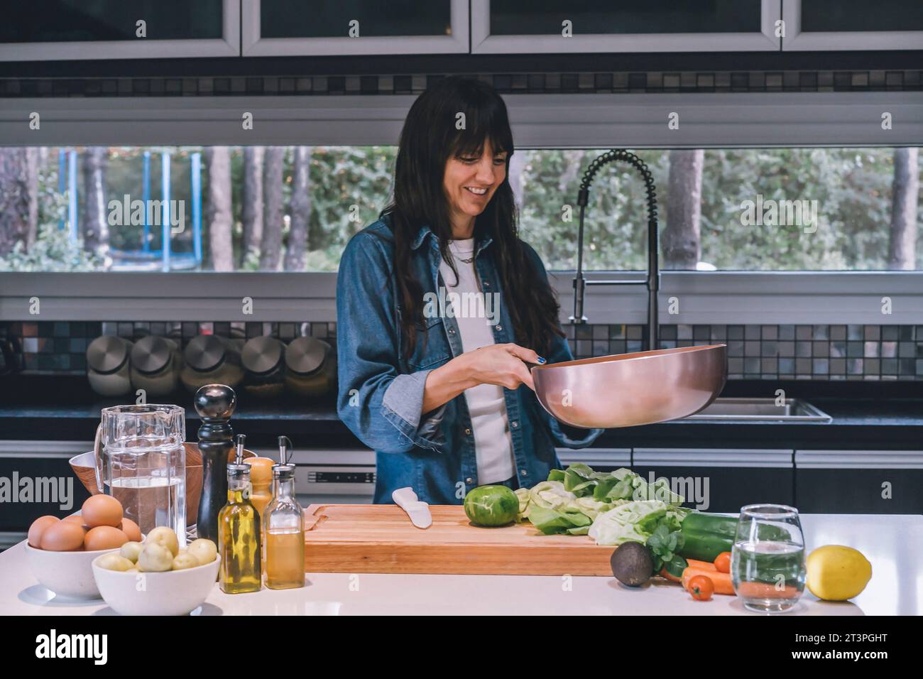 A woman cooking vegetables in a copper wok Stock Photo - Alamy