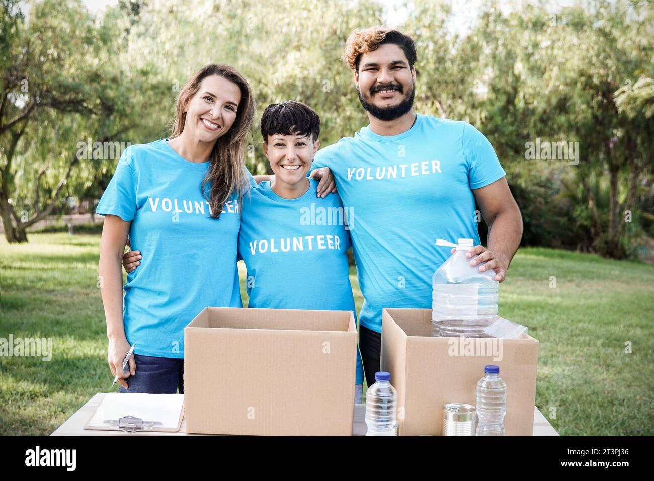 Multiracial team of volunteers working collecting goods and food for ...