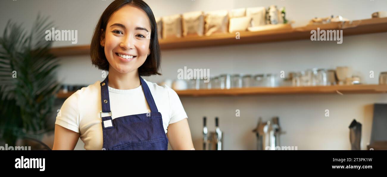 Vertical shot of barista, asian girl in cafe using tamper for coffee ...