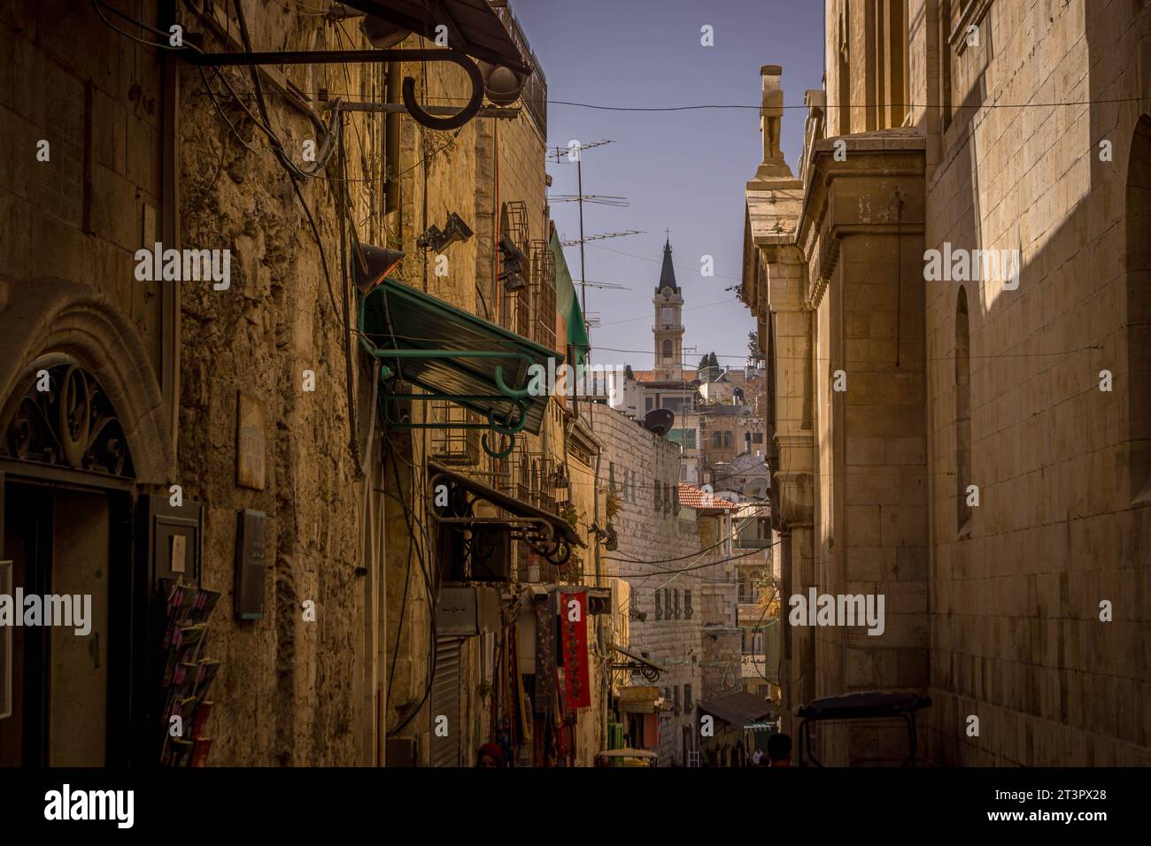 The tower of the christian church is seen through the narrow street ...