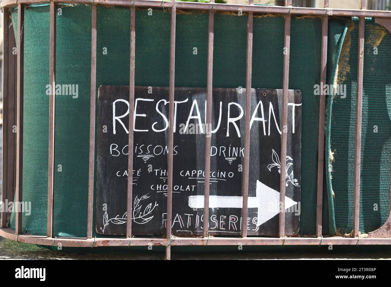 Hand written Restaurant signage written on glass behind iron bars on ...