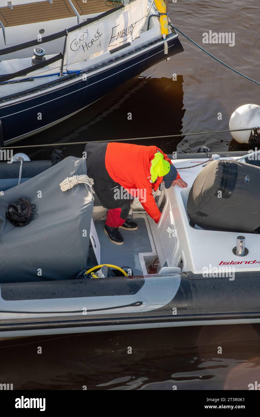 yachtsman or sailor working on a modern rib or rigid inflatable boat ...