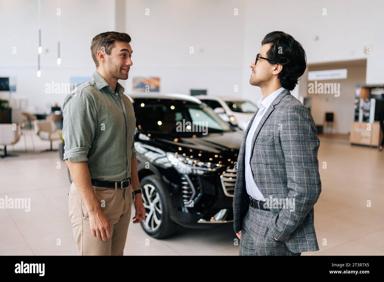 Side view of stylish professional male car seller with happy male ...