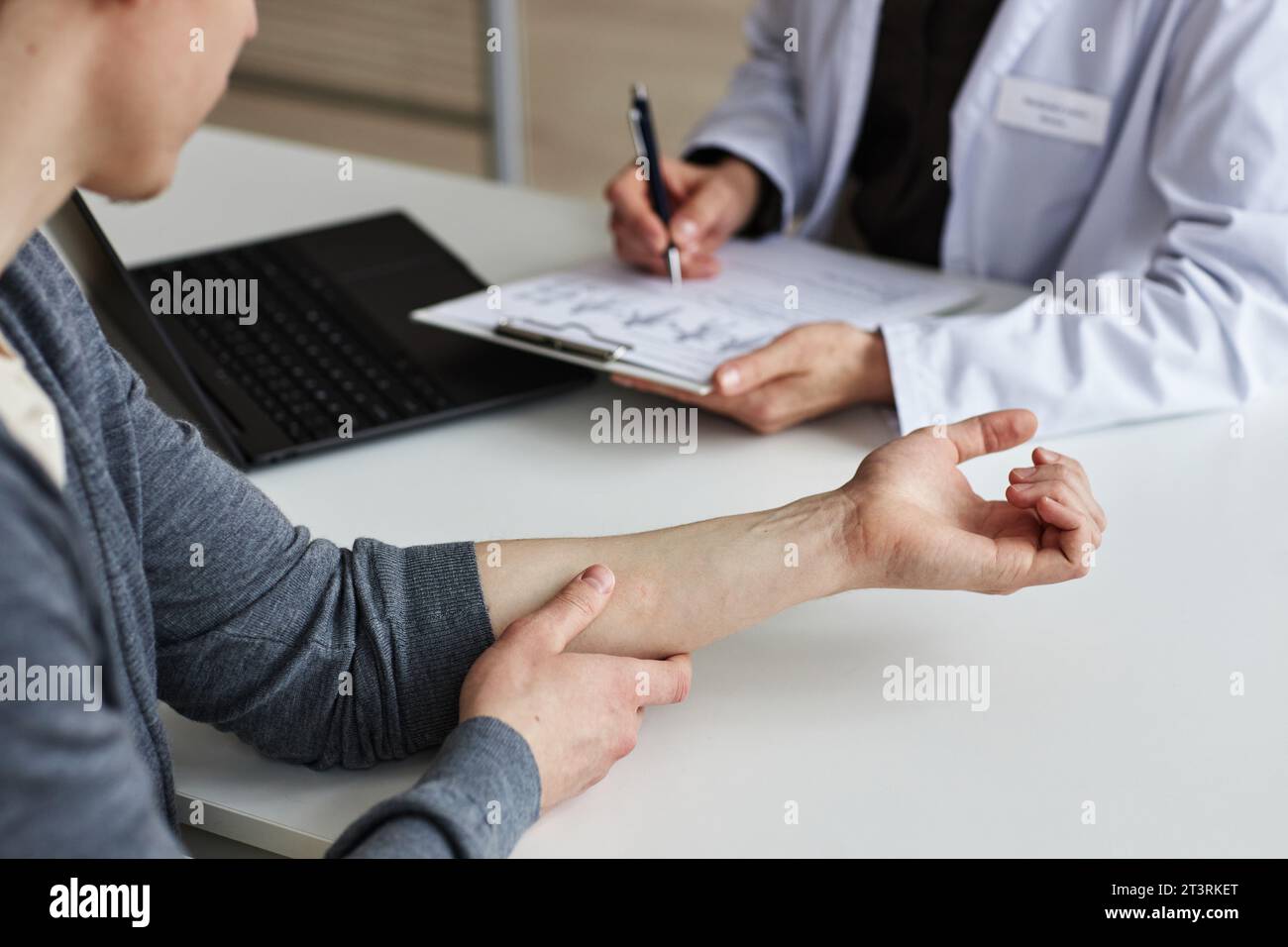 Close up of young man showing skin on forearm during visit to ...