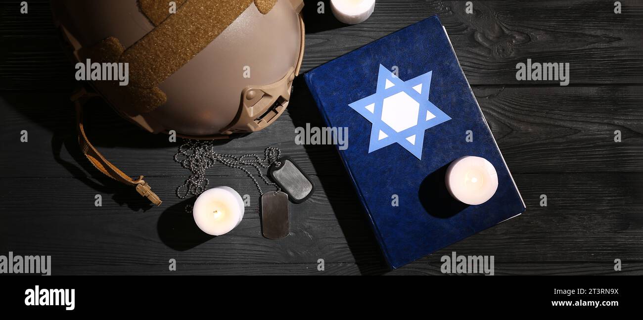 Torah, burning candles, dog tags and military helmet on dark wooden ...