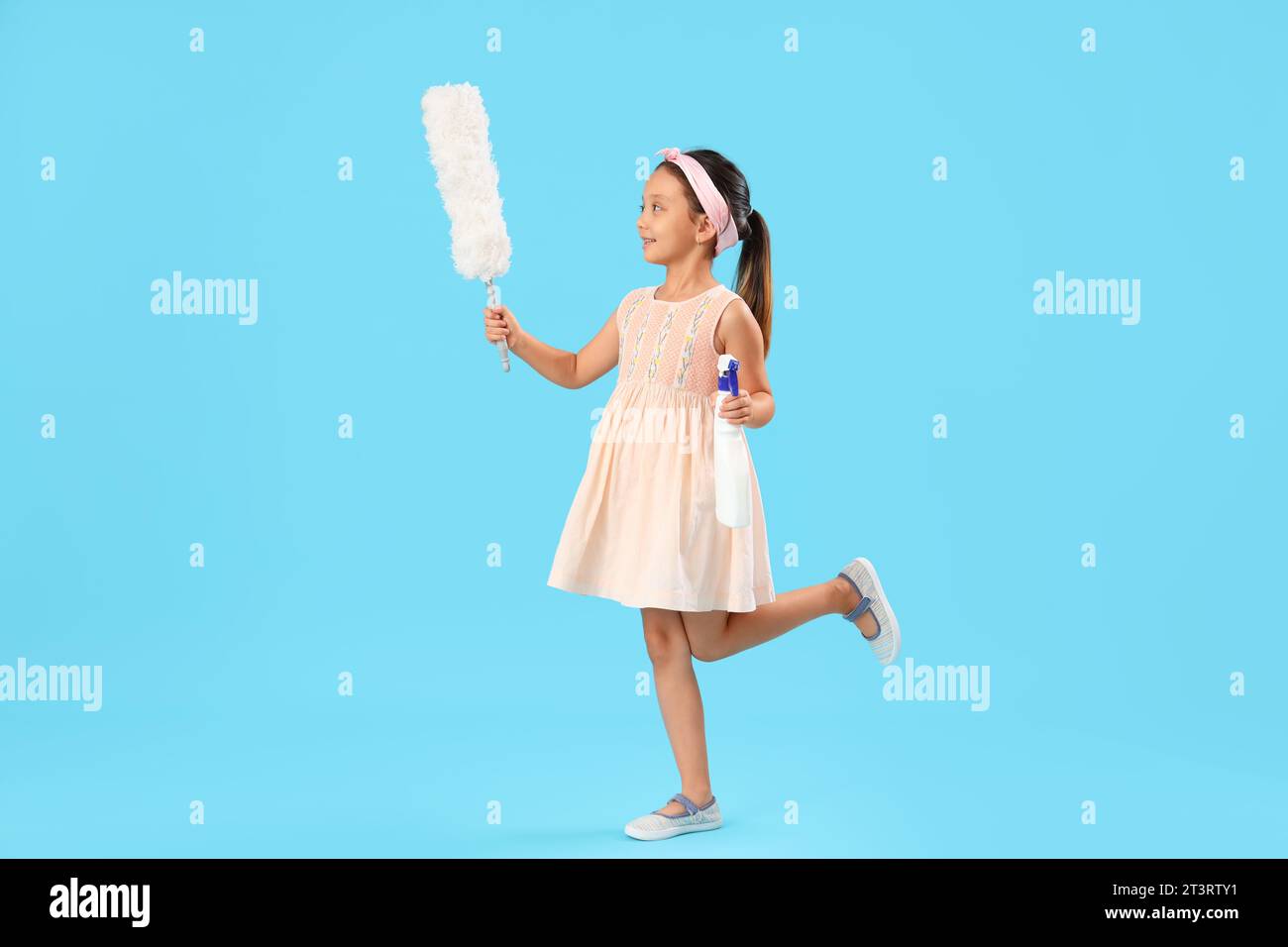 Cute little girl with pp-duster on blue background Stock Photo - Alamy