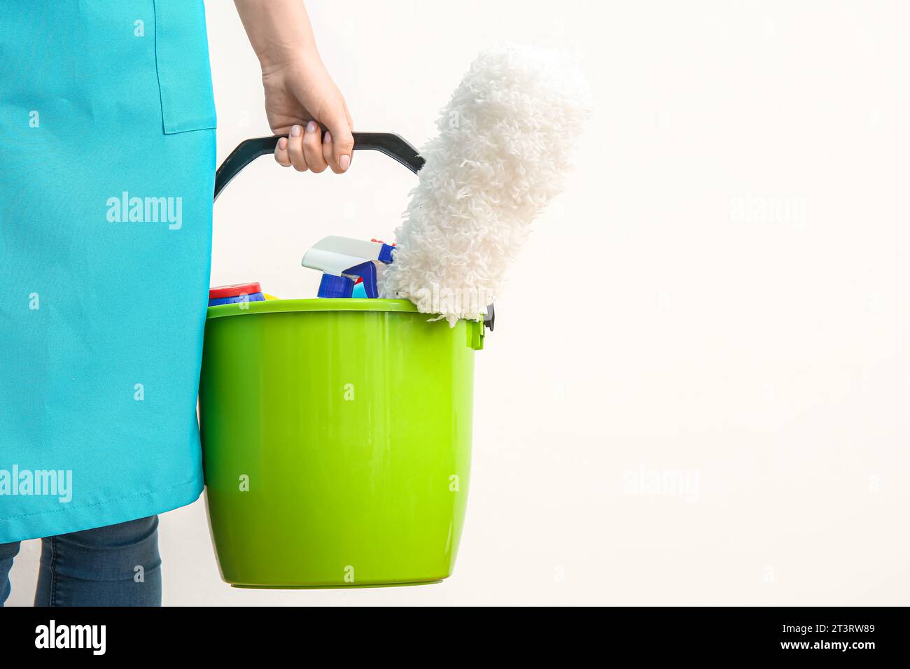 Cleaning service worker holding bucket with supplies on beige ...